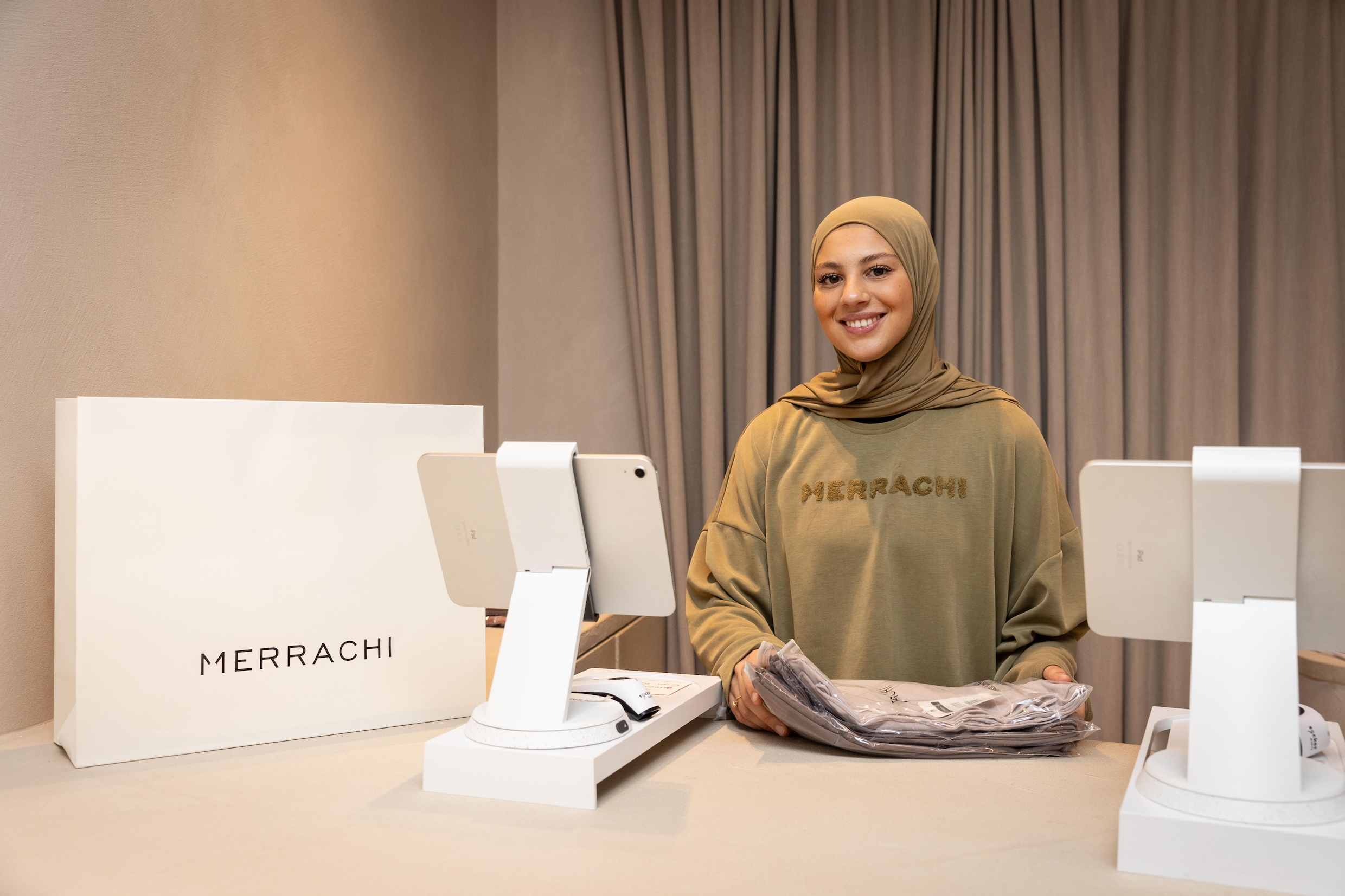 Vrouwen met en zonder hoofddoek staan in de rij voor kleding van ...