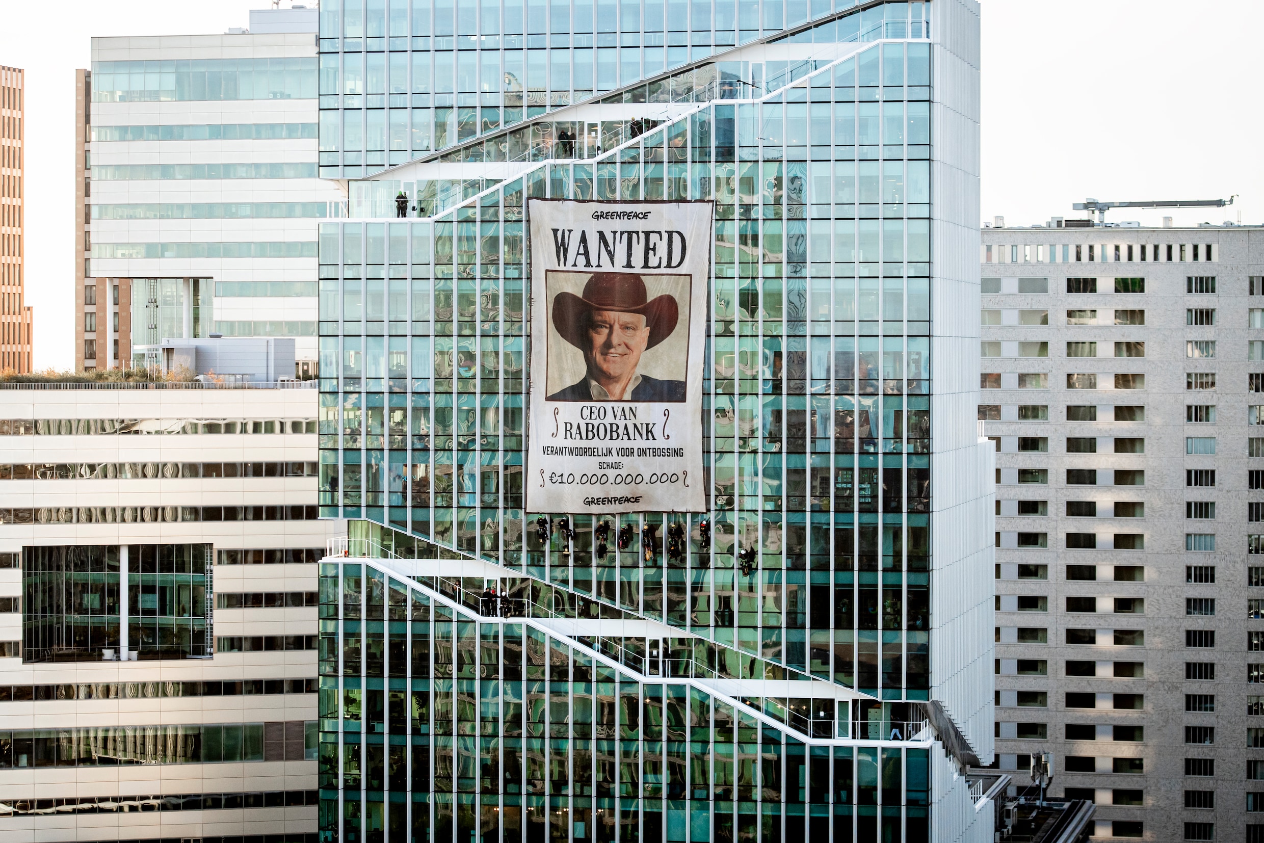 Greenpeace rolt enorm spandoek uit op Zuidasgebouw: ‘Wanted: ceo van ...